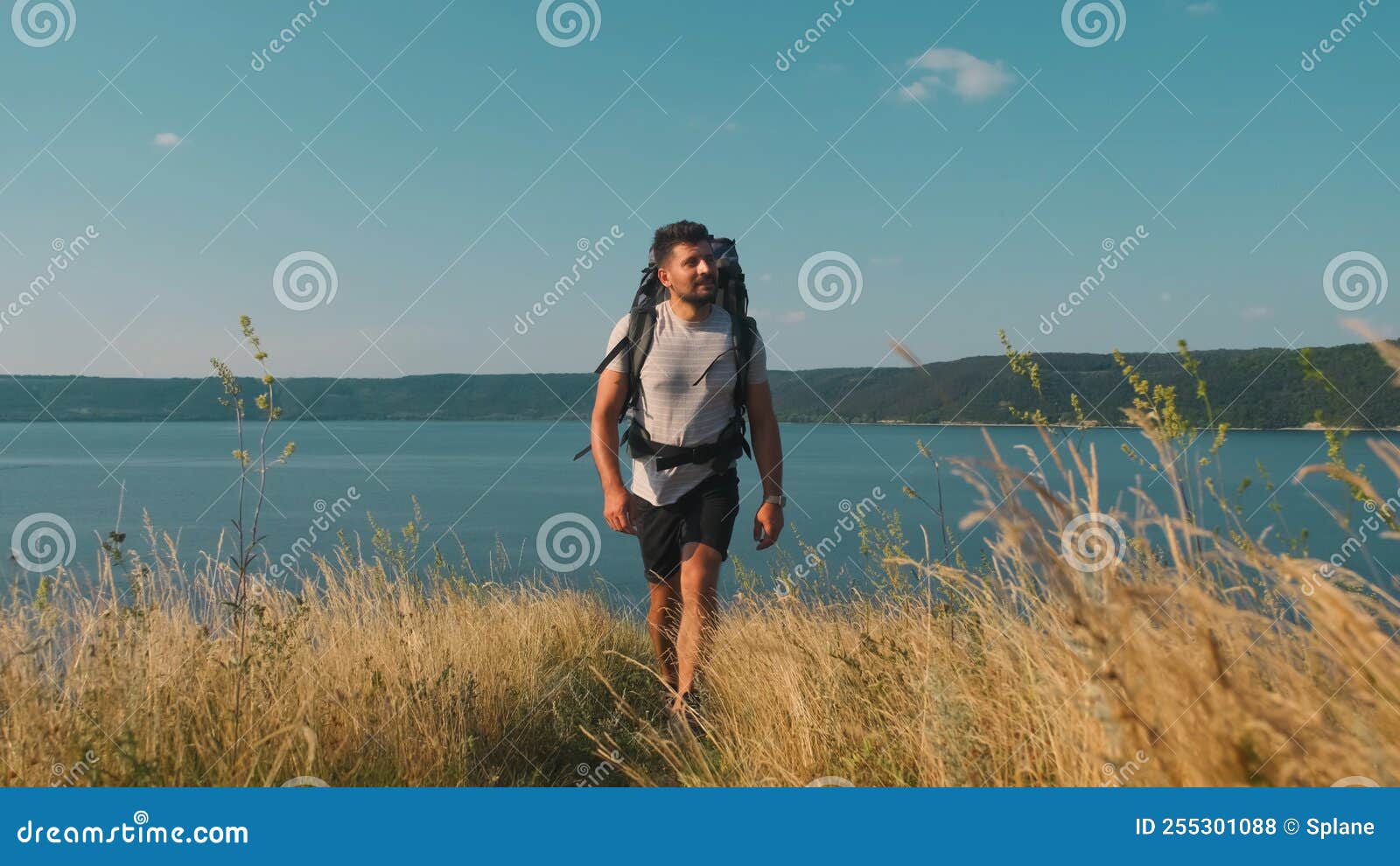 The Handsome Man Walking with Backpack Along the Coast. Stock Photo ...