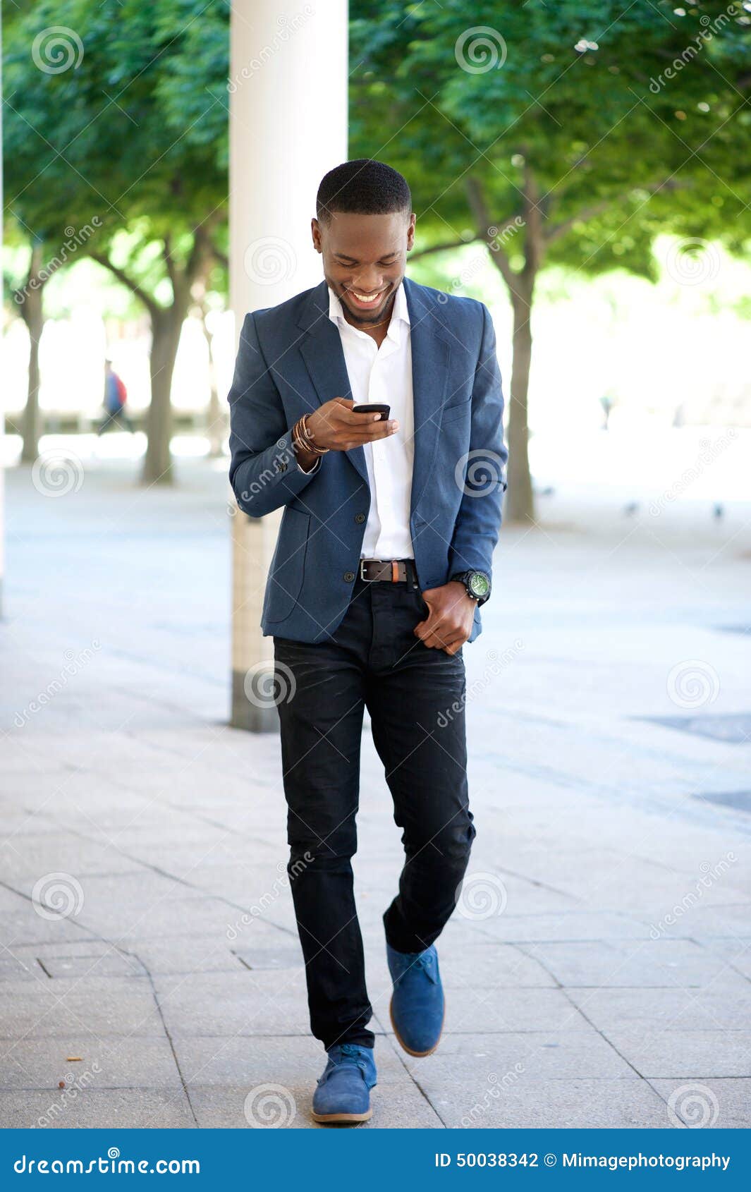 Handsome Man Walking and Sending Text Message on Cellphone Stock Photo ...