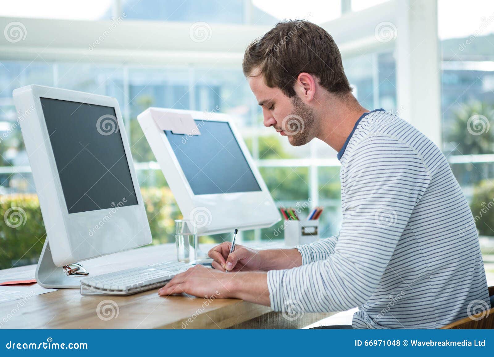 Handsome Man Working on Computer and Taking Notes Stock Photo - Image ...