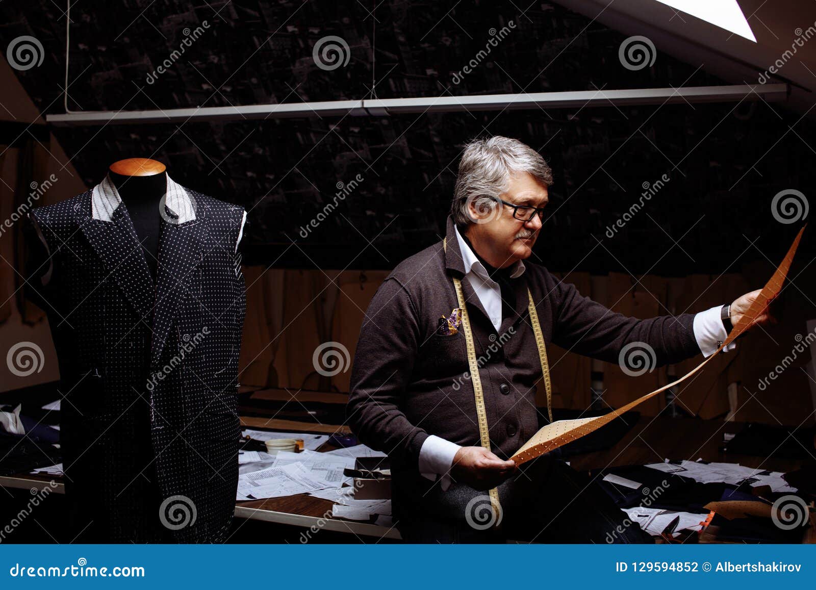 Mature Tailor Working with Cut Patterns at Workshop in Late Evening ...