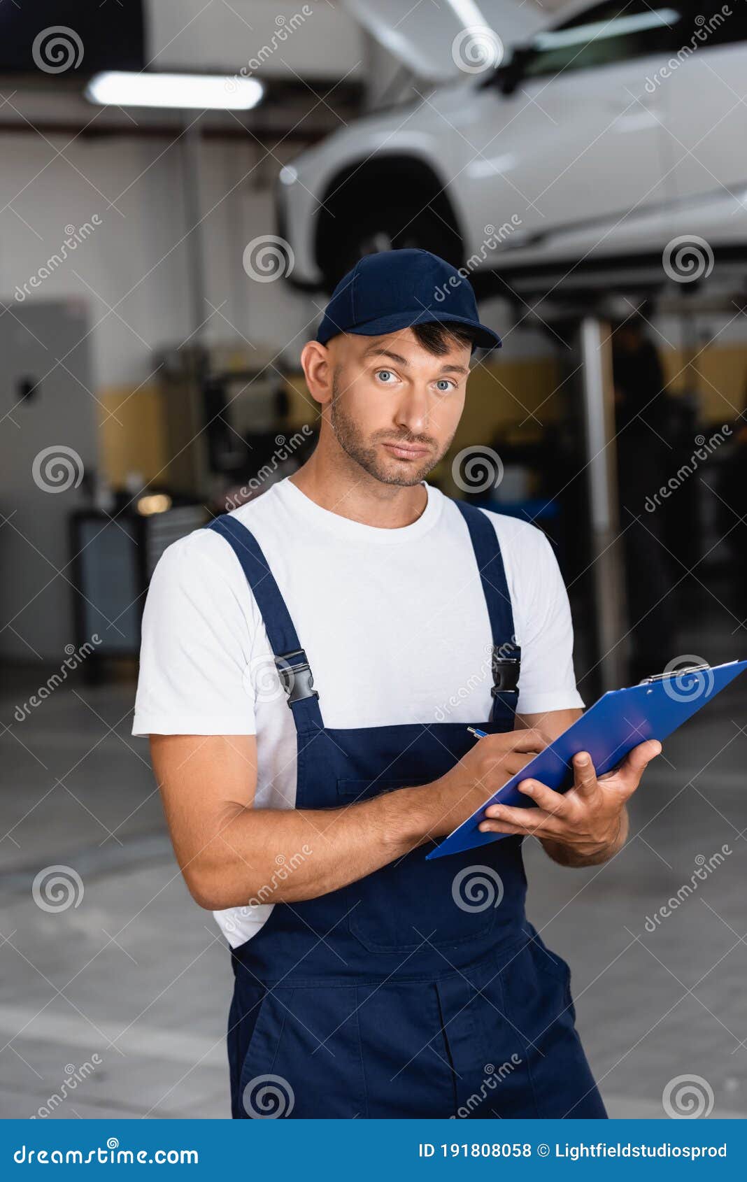 Handsome Mechanic in Uniform and Cap Stock Photo - Image of write ...