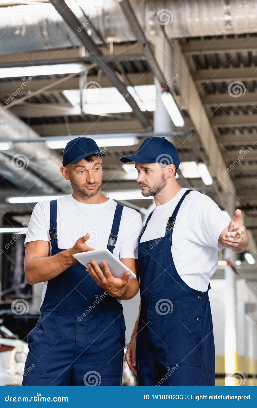 Handsome Mechanics in Uniform Using Digital Stock Image - Image of ...