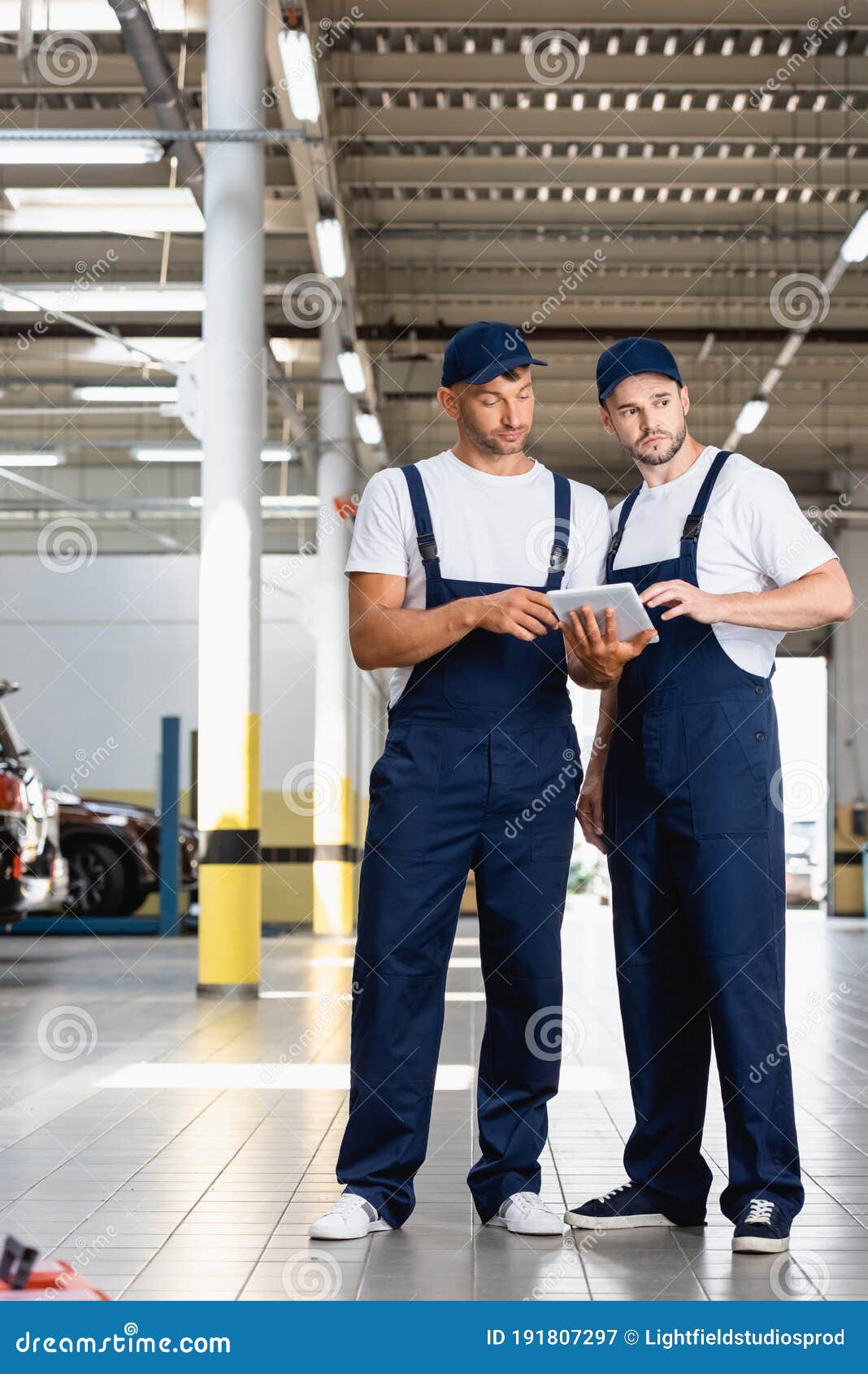 Handsome Mechanics in Uniform Using Digital Stock Image - Image of ...