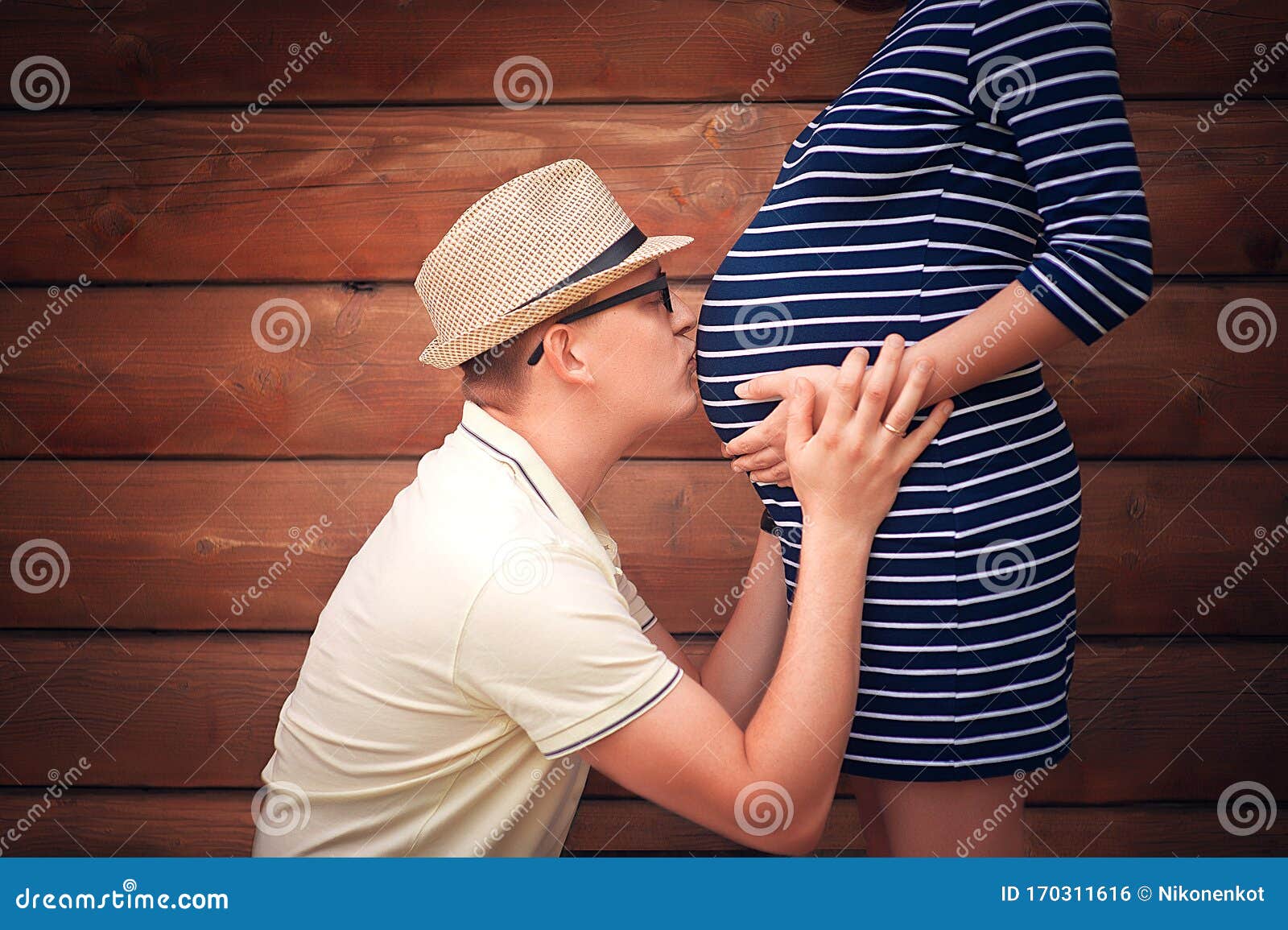 Handsome Man And His Beautiful Pregnant Wife Hugging And Smiling For A