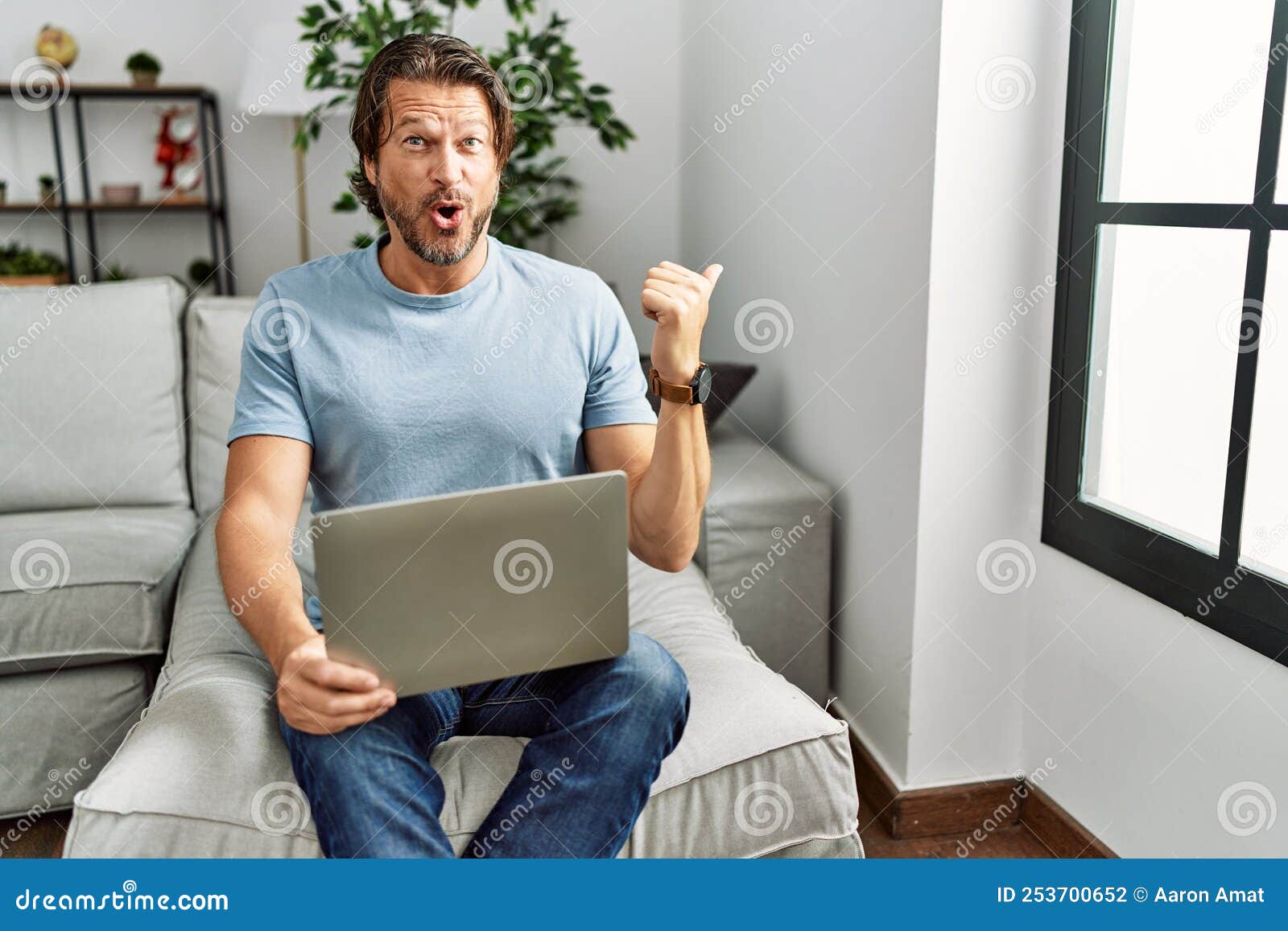 Handsome Middle Age Man Using Computer Laptop on the Sofa Surprised ...