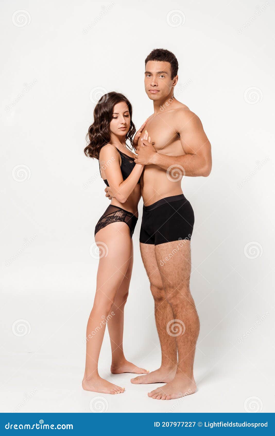 Handsome Mixed Race Man Hugging Woman In Black Underwear On White
