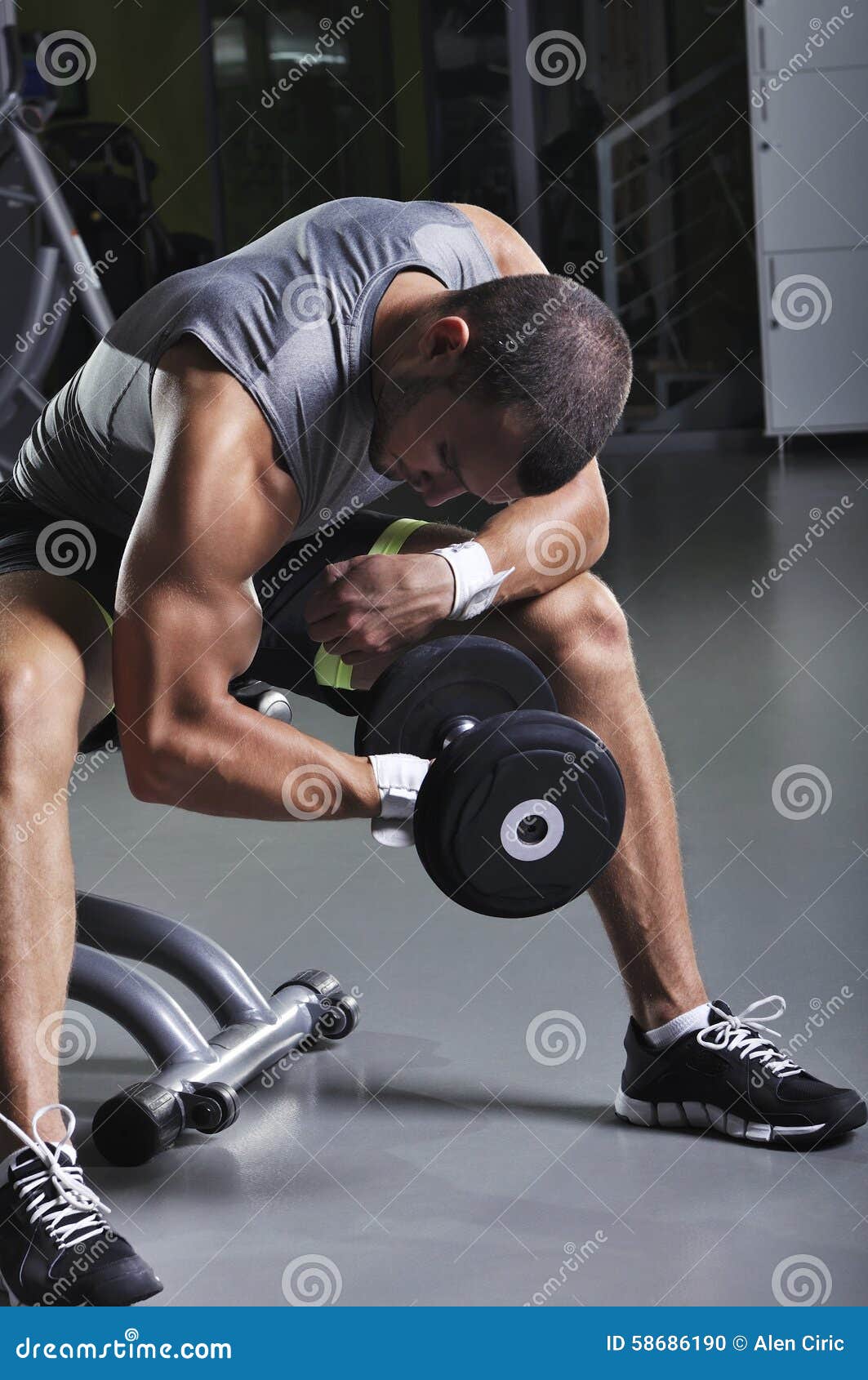 Handsome Muscular Male Model in a Sitting Position Doing Biceps Stock ...