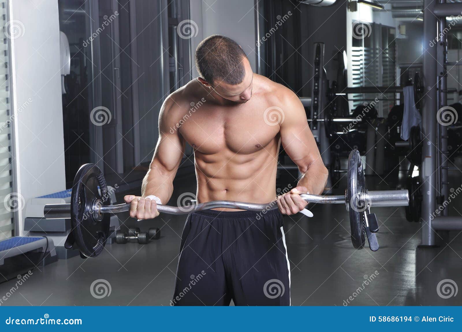 Handsome Muscular Male Model in a Standing Position Doing Biceps Stock ...