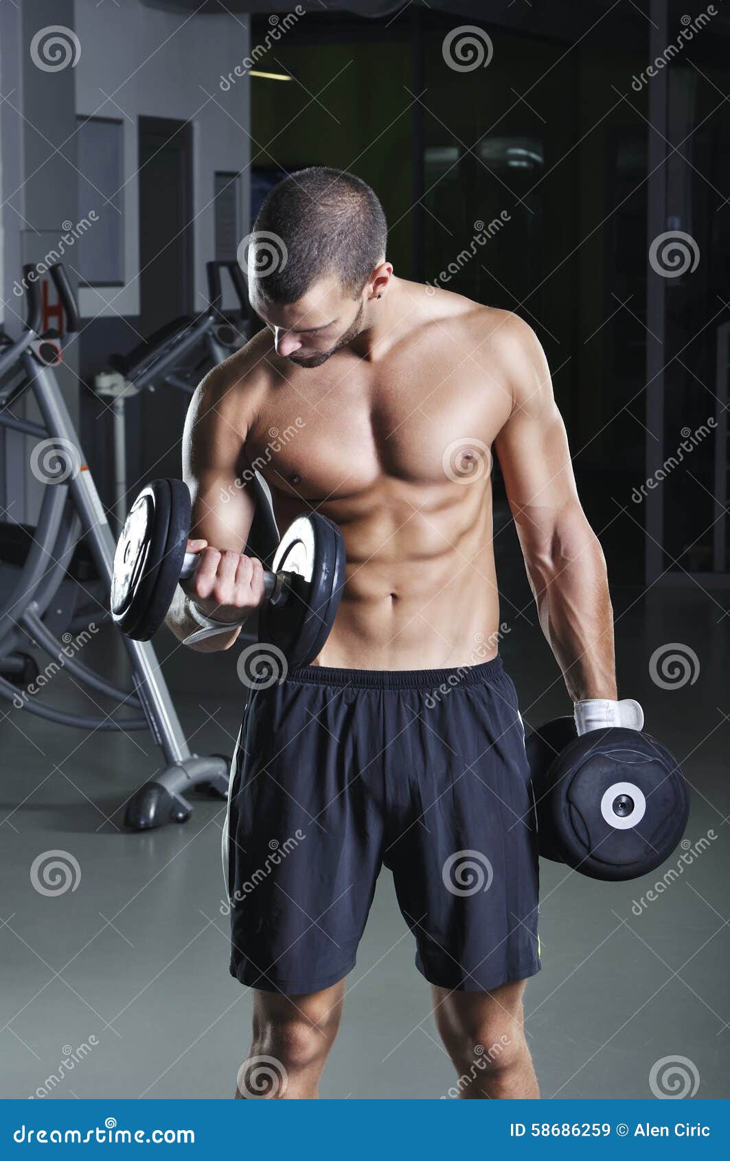 Handsome Muscular Male Model in a Standing Position Doing Biceps Stock ...