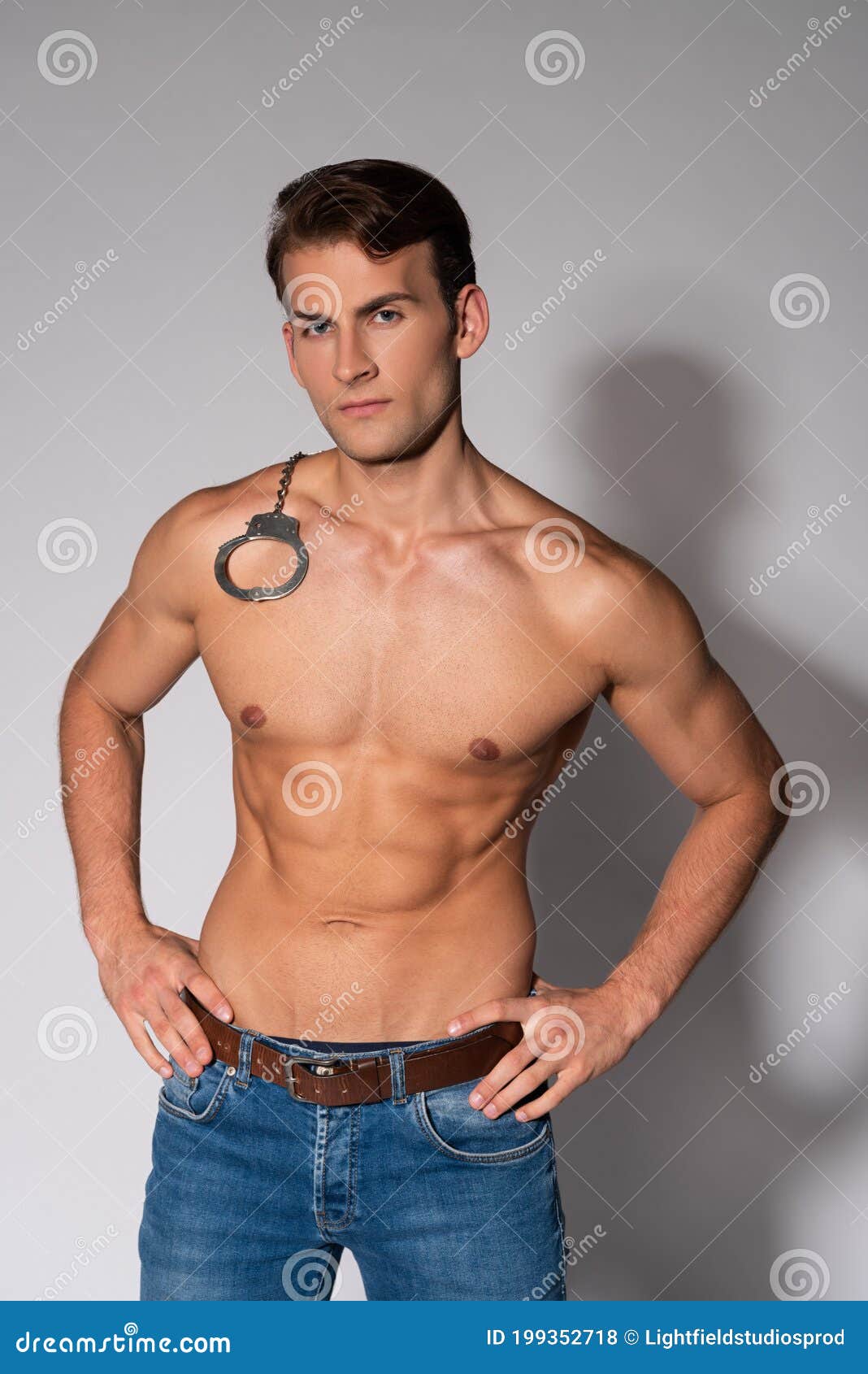 Muscular Man with Handcuffs Standing with Hands on Hips on White Stock ...