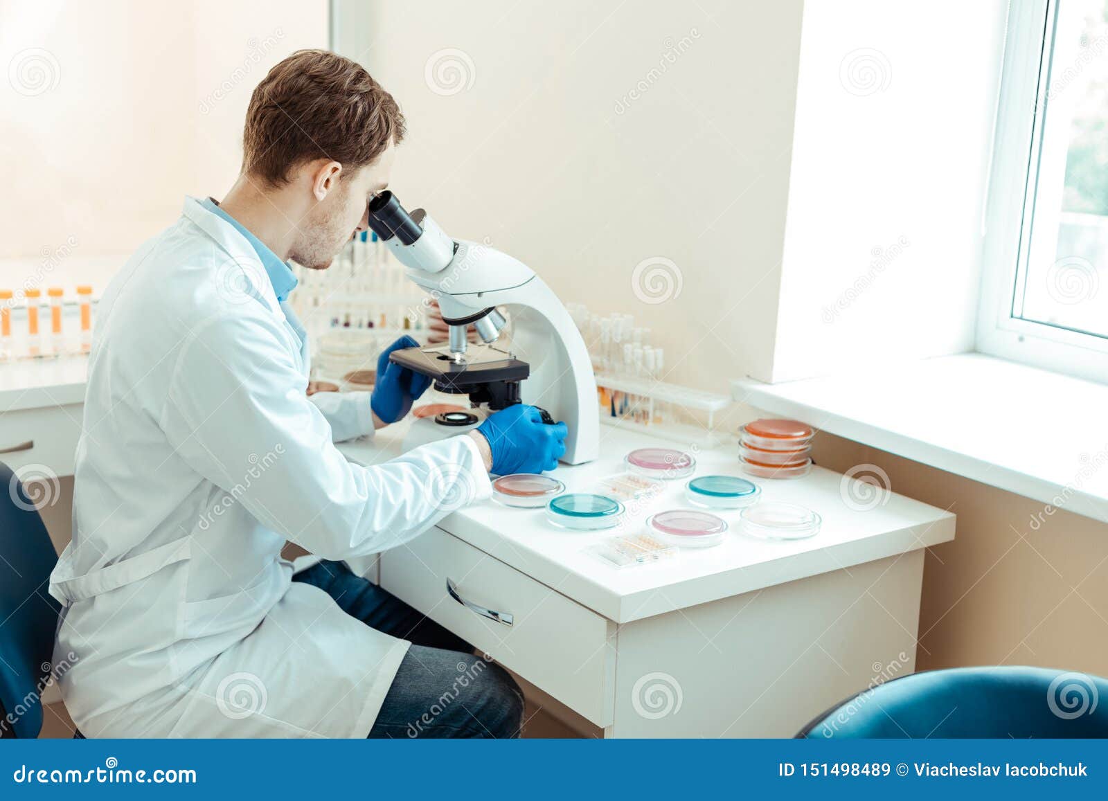 Handsome Nice Man Sitting in Front of the Microscope Stock Image ...