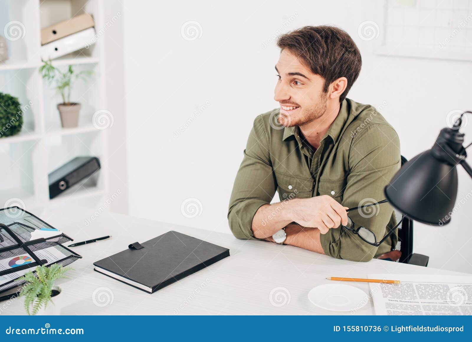 Handsome Office Manager Sitting At Desk With Notebook And Papers