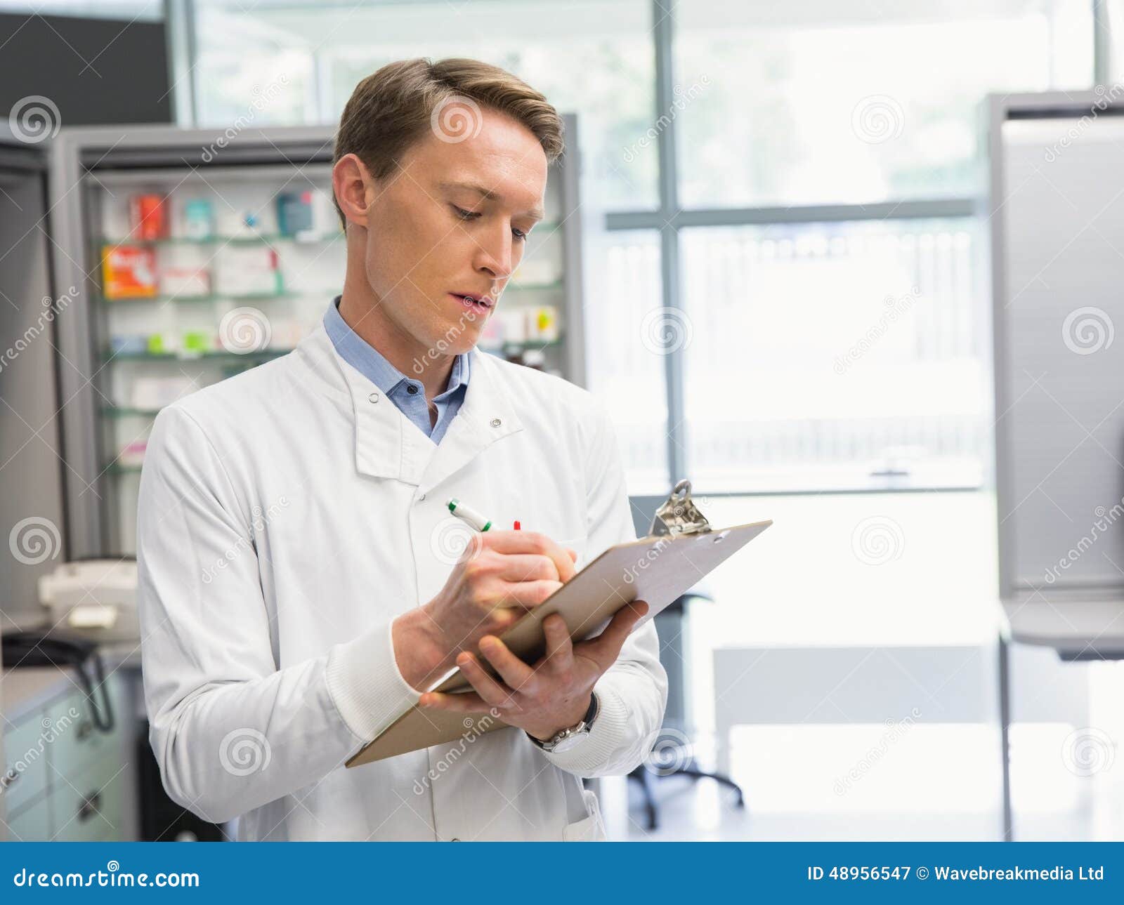 Handsome Pharmacist Writing on Clipboard Stock Image - Image of drug ...