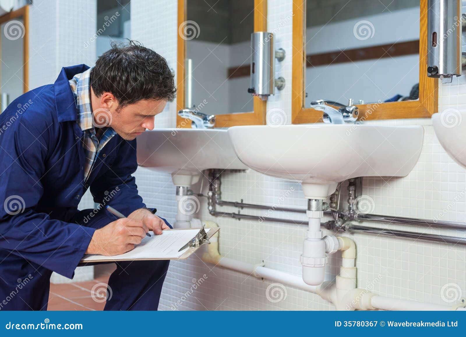 Handsome Plumber Looking at Sink Holding Clipboard Stock Image - Image ...