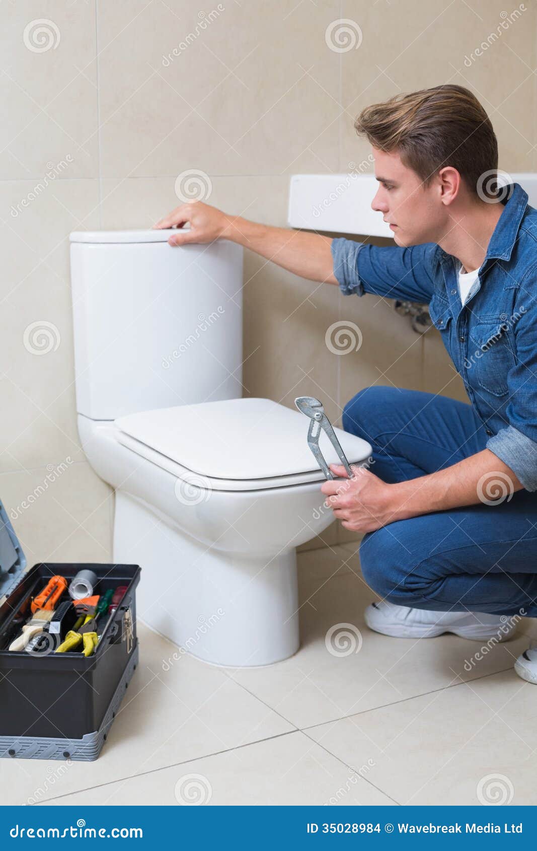 Handsome Plumber with Toolbox Doing Toilet Reparation Stock Photo ...