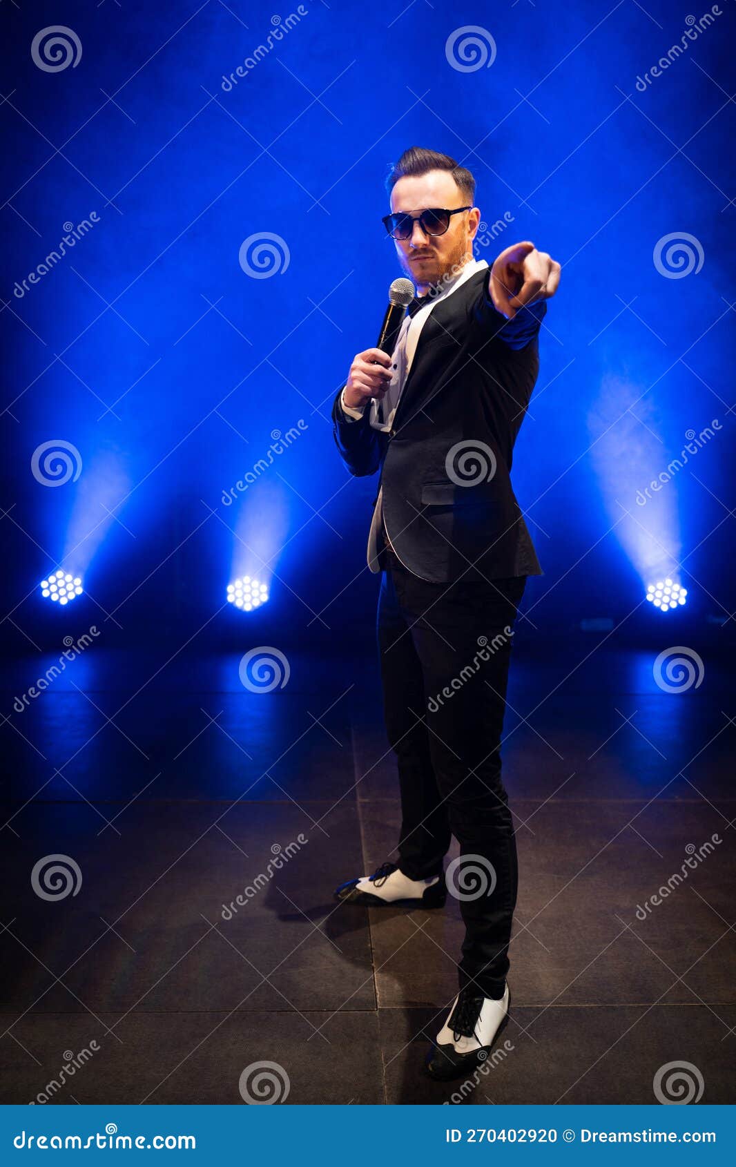Handsome Presenter and Showman in a Stylish Suit with a Microphone on ...