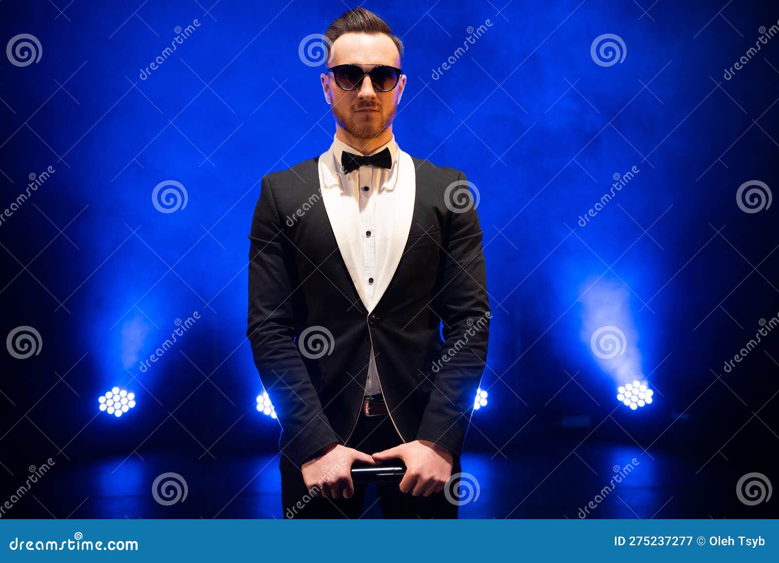 Handsome Presenter and Showman in a Stylish Suit with a Microphone on ...