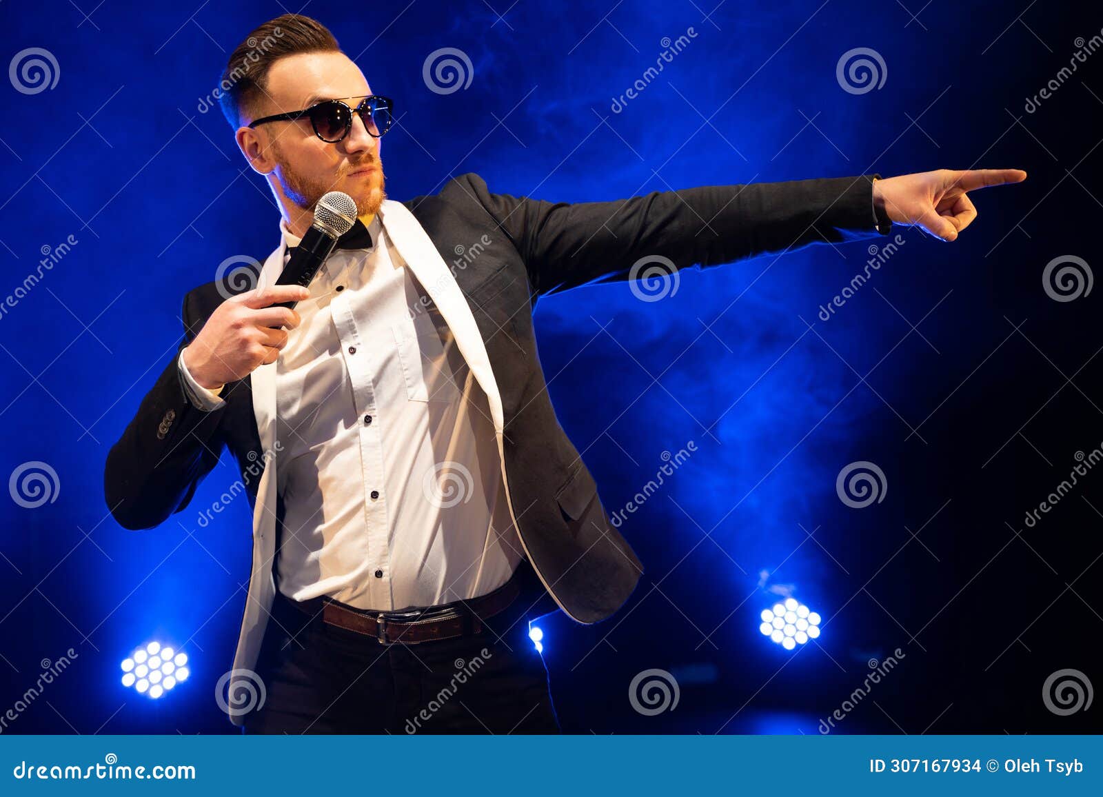 Handsome Presenter and Showman in a Stylish Suit with a Microphone on ...