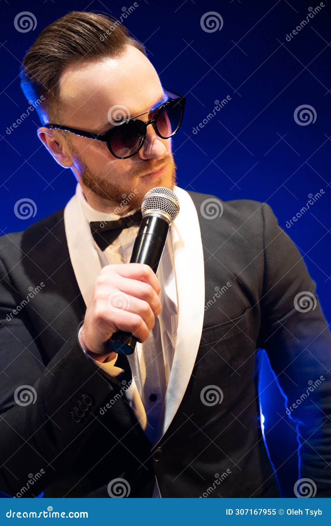 Handsome Presenter and Showman in a Stylish Suit with a Microphone on ...