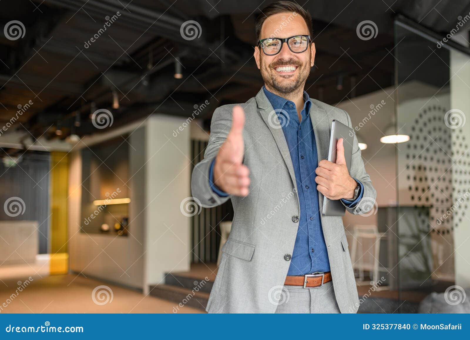 Handsome Professional with Laptop Smiling and Offering Handshake while ...