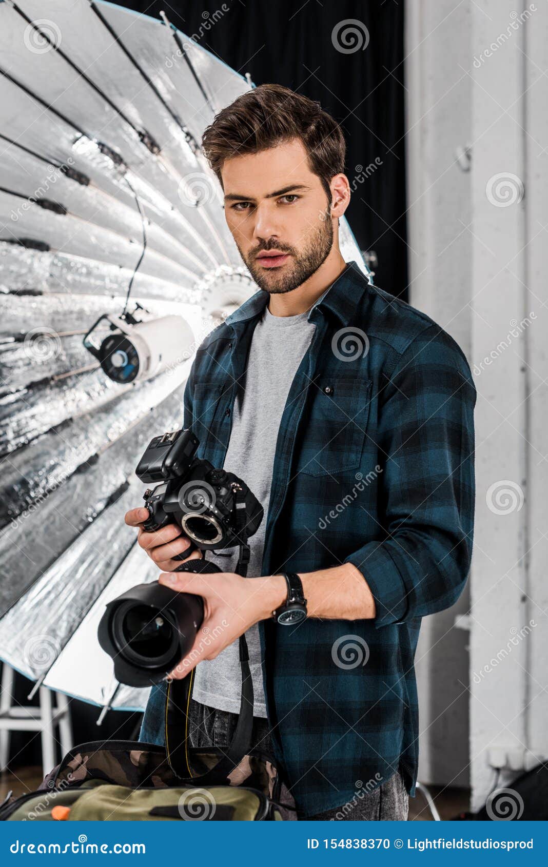 Handsome Professional Young Photographer Holding Camera and Lens Stock ...