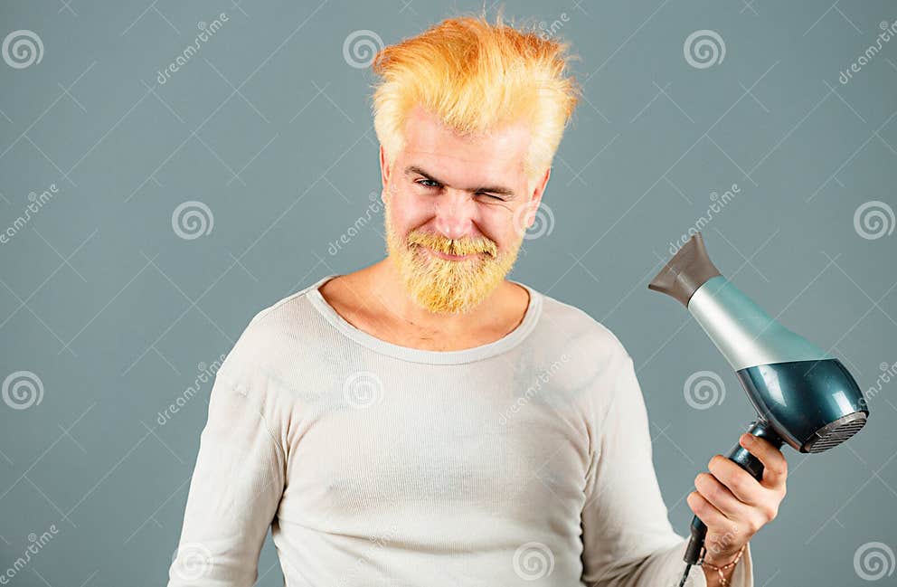 Handsome Redhead Man With Long Hair Dries His Hair With A Hairdryer