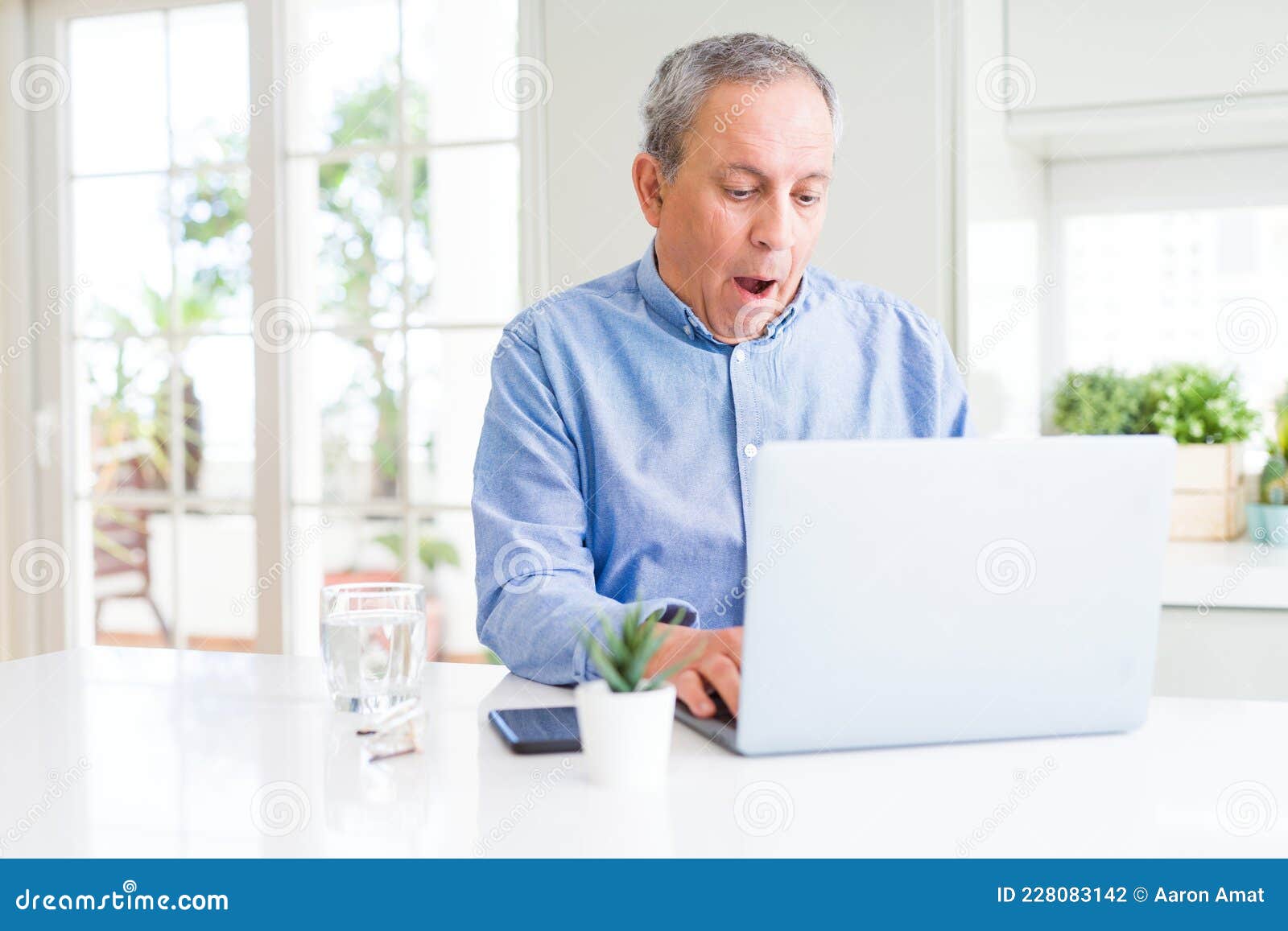 Handsome Senior Man Using Computer Laptop Working on Internet Scared in ...