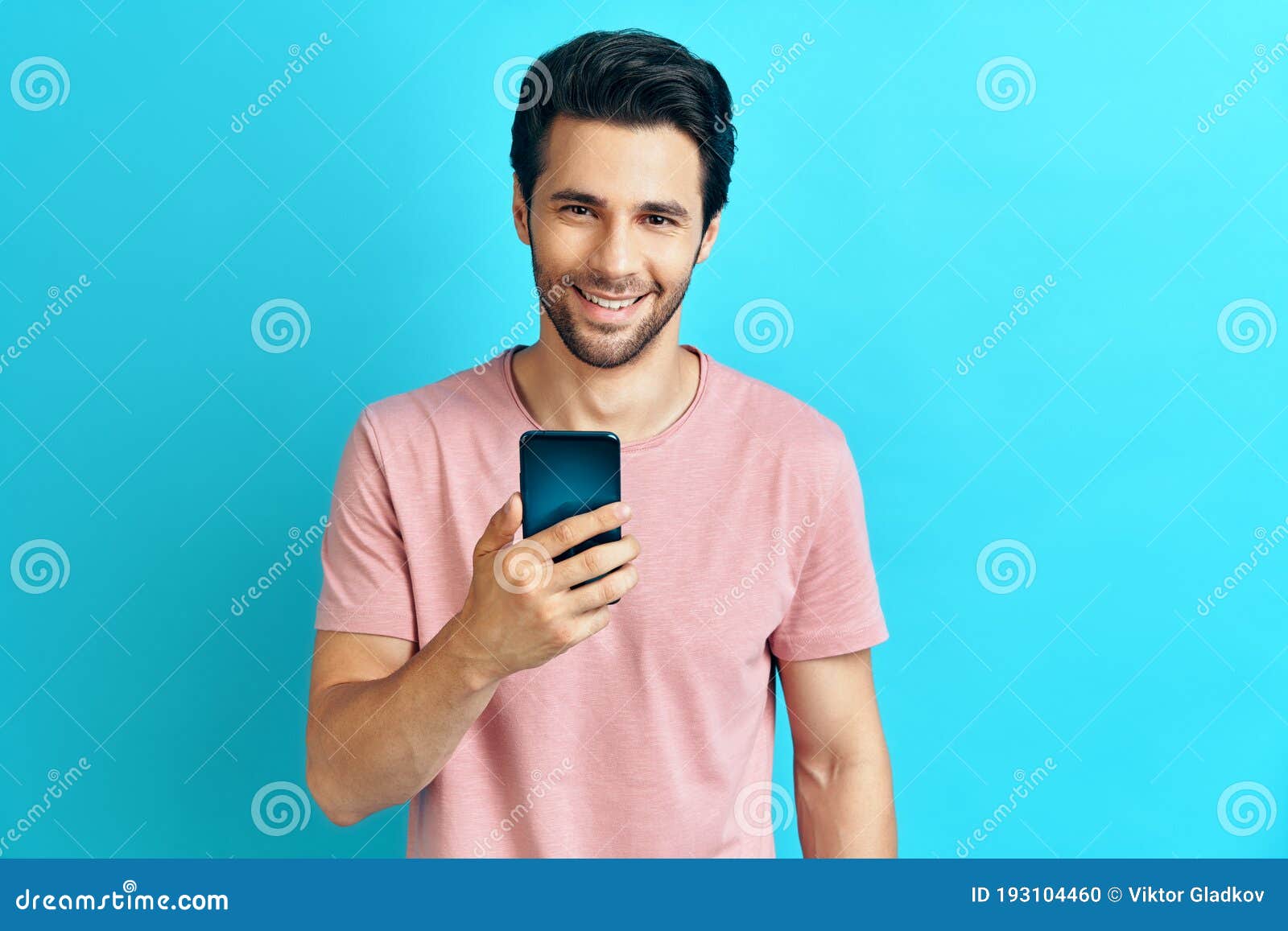 Handsome Smiling Man Holding Mobile Phone and Looking To Camera Stock ...