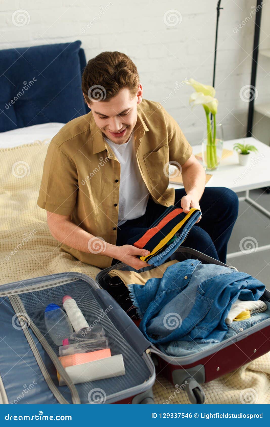 Handsome Smiling Man Packing Clothes Stock Photo - Image of tourist ...