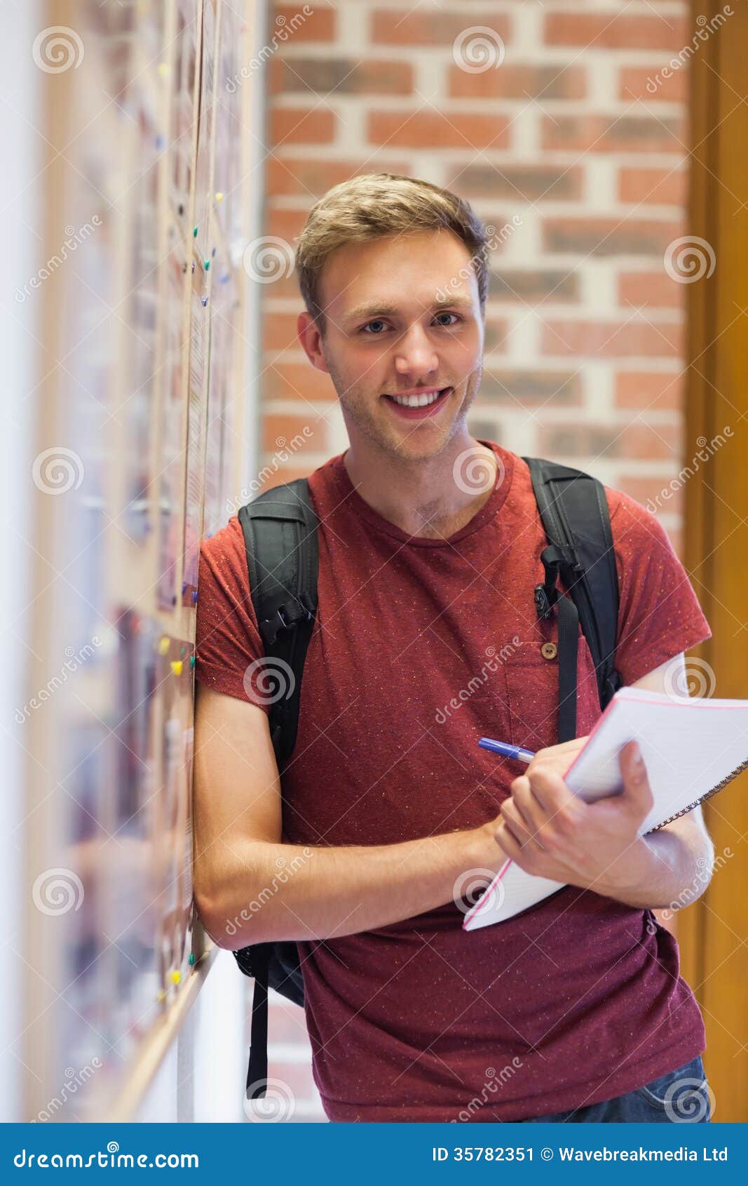 Handsome Smiling Student Taking Notes Next To Notice Board Stock Image ...