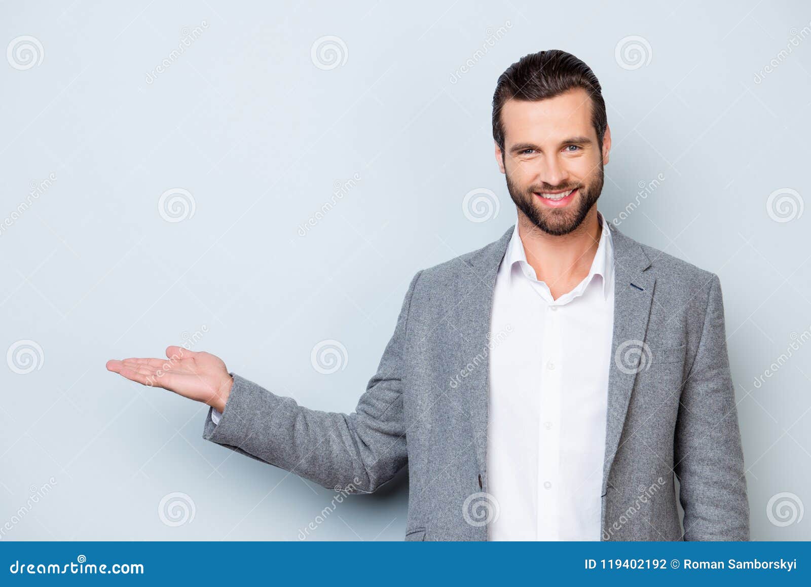 Handsome Smiling Young Man In Jacket Showing On Copyspace With H Stock ...