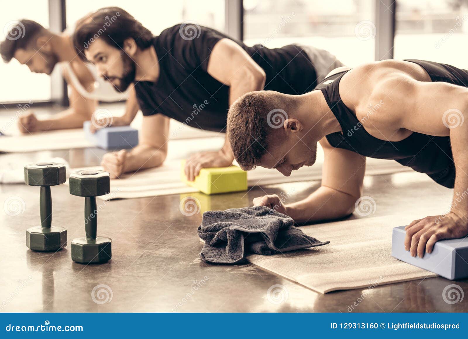 Handsome Sportsmen Simultaneously Doing Plank and Using Blocks Stock ...