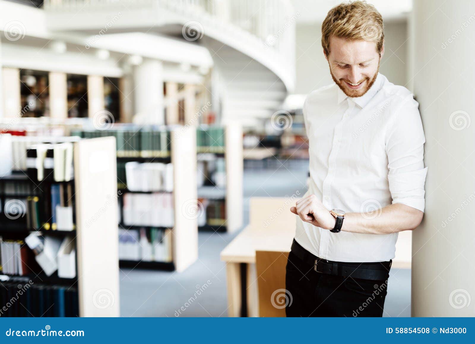 Handsome Student Checking Time in Library Stock Photo - Image of wall ...