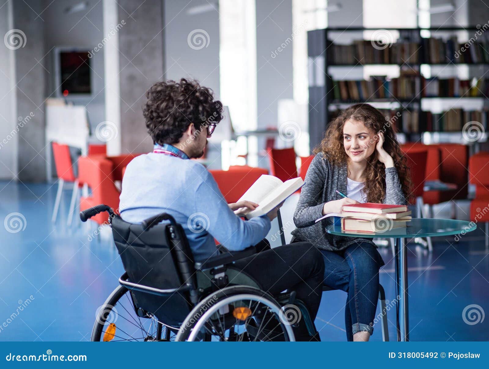 Handsome University Student in Wheelchair Studying in Library with ...