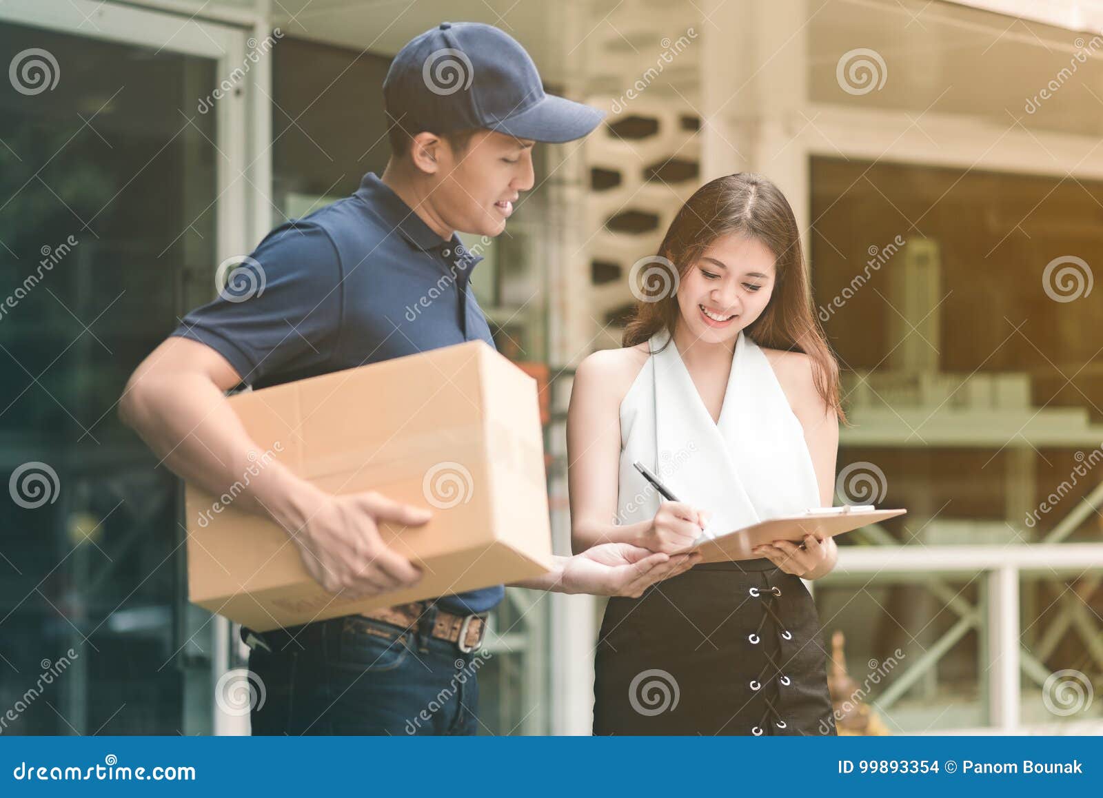 Handsome Young Asian Delivery Man Smiling and Holding a Cardboard Box ... Handsome Young Asian Delivery Man Smiling and Holding a Cardboard Box ...