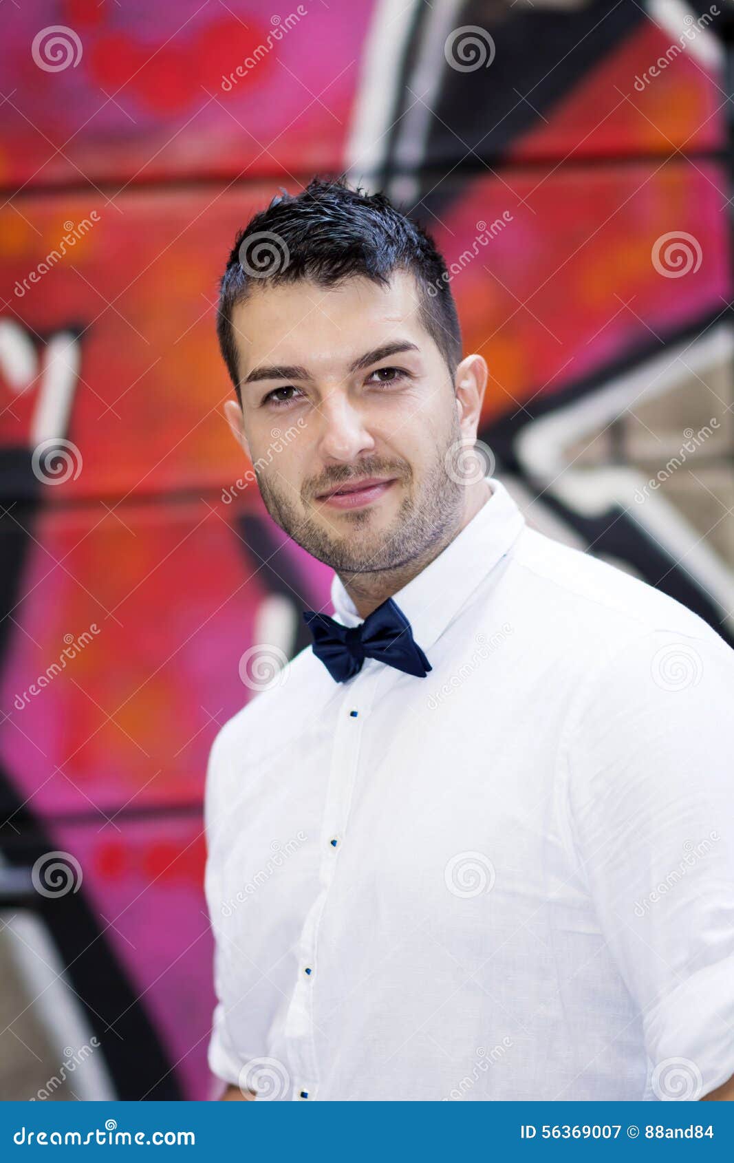 Handsome Young Bearded Man With White Shirt And Bow Tie On The Street