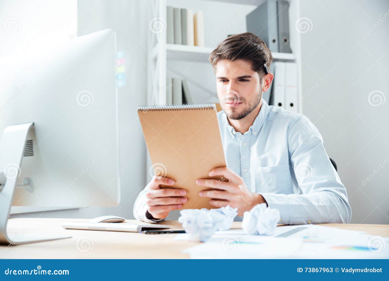 Handsome Young Businessman Man Sitting and Reading Notes in Notebook ...