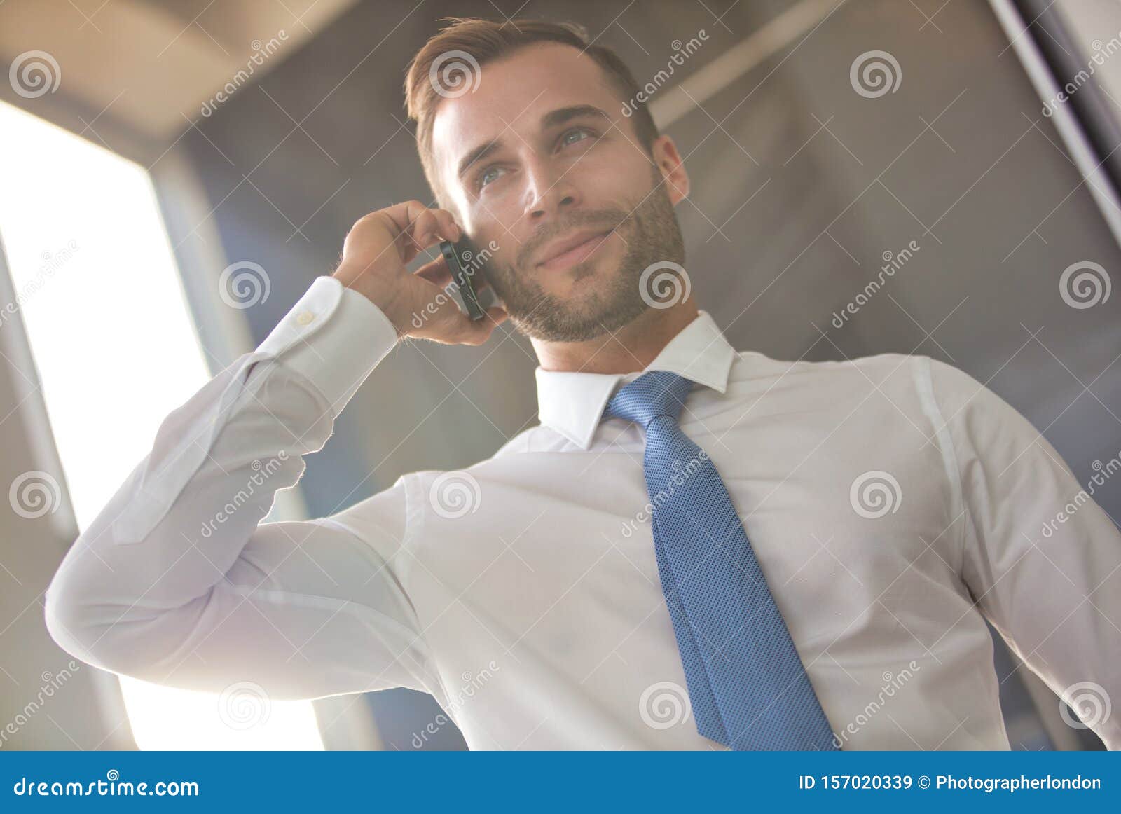 Handsome Young Businessman Smiling While Talking On Smart Phone While