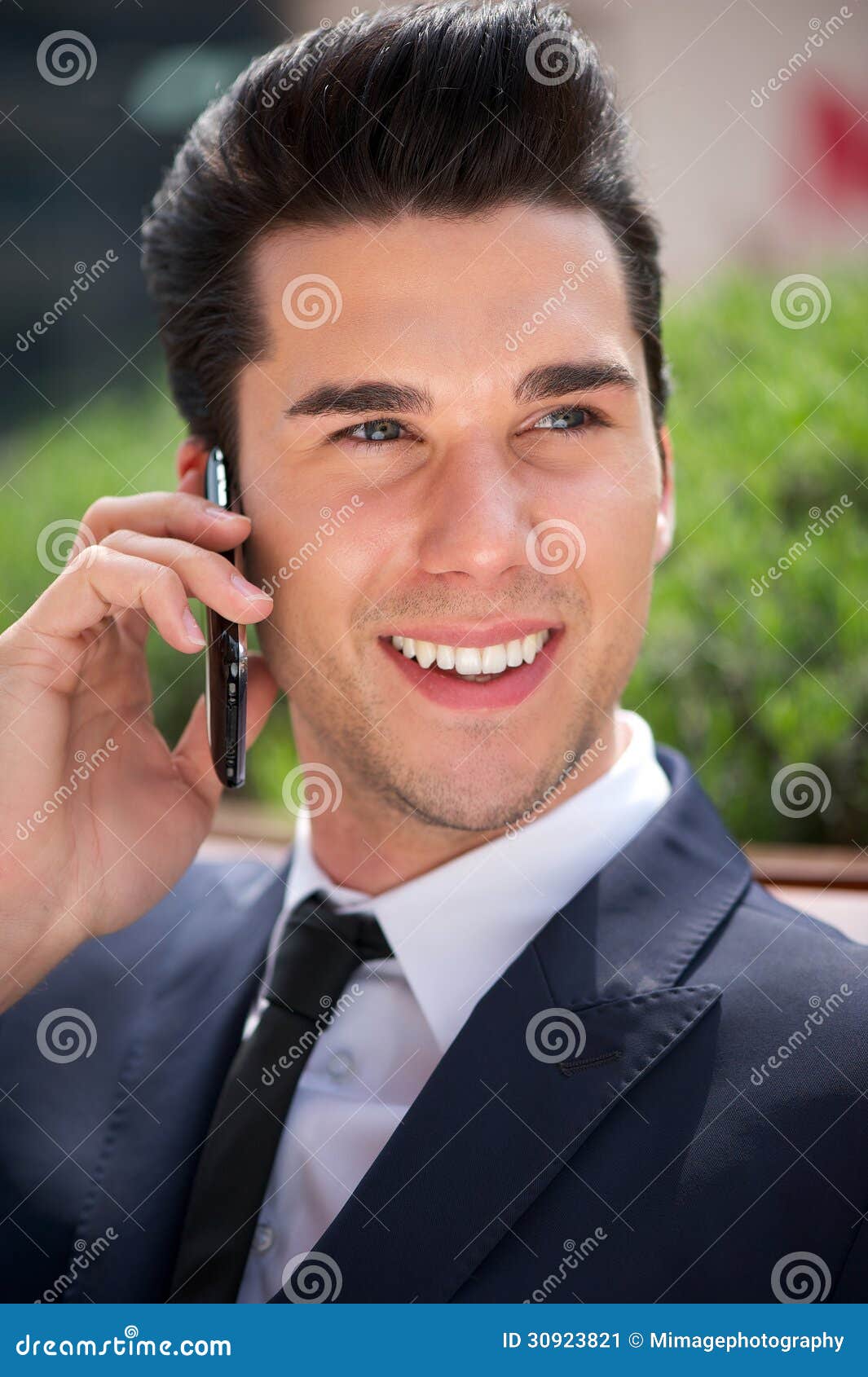 Handsome Young Businessman Talking On Phone Outdoors Stock Image