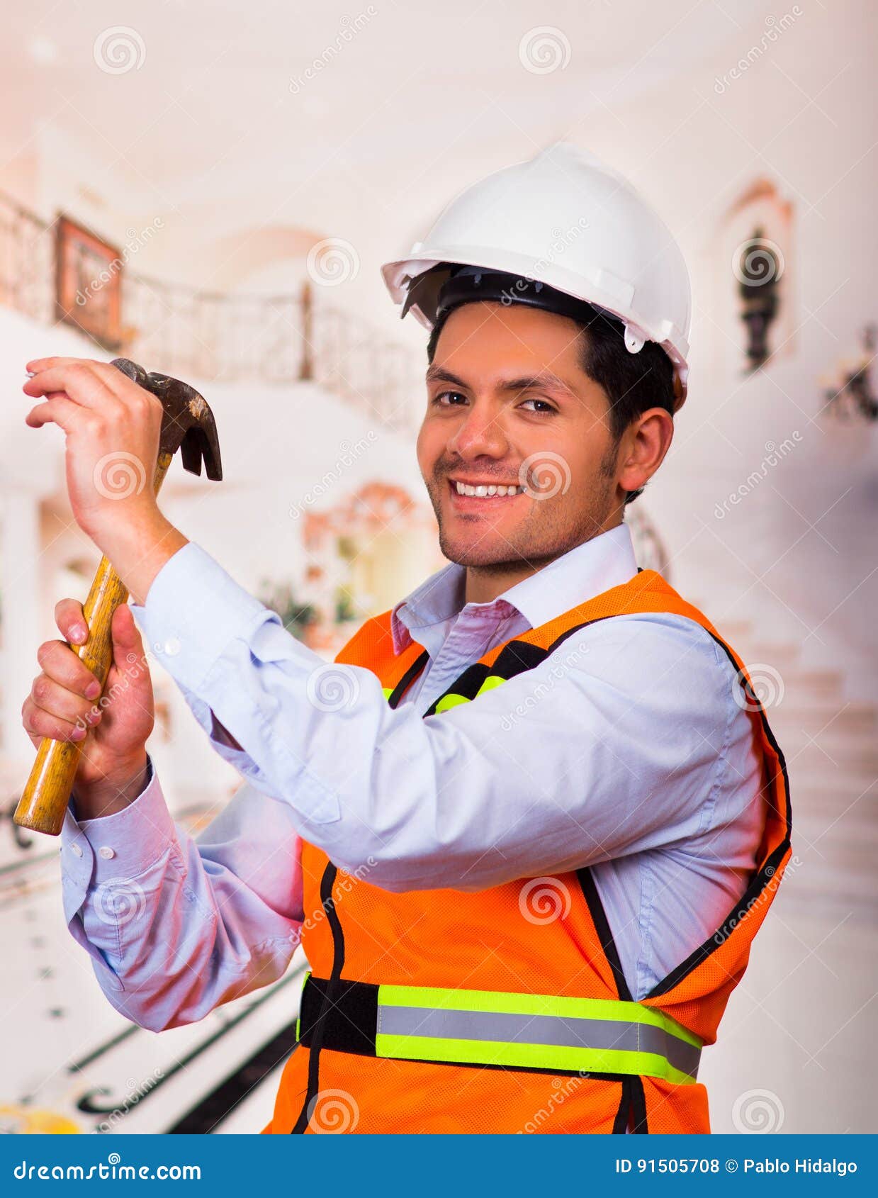 Handsome Young Engineer Using a Hammer in His Hand at Construction Site ...