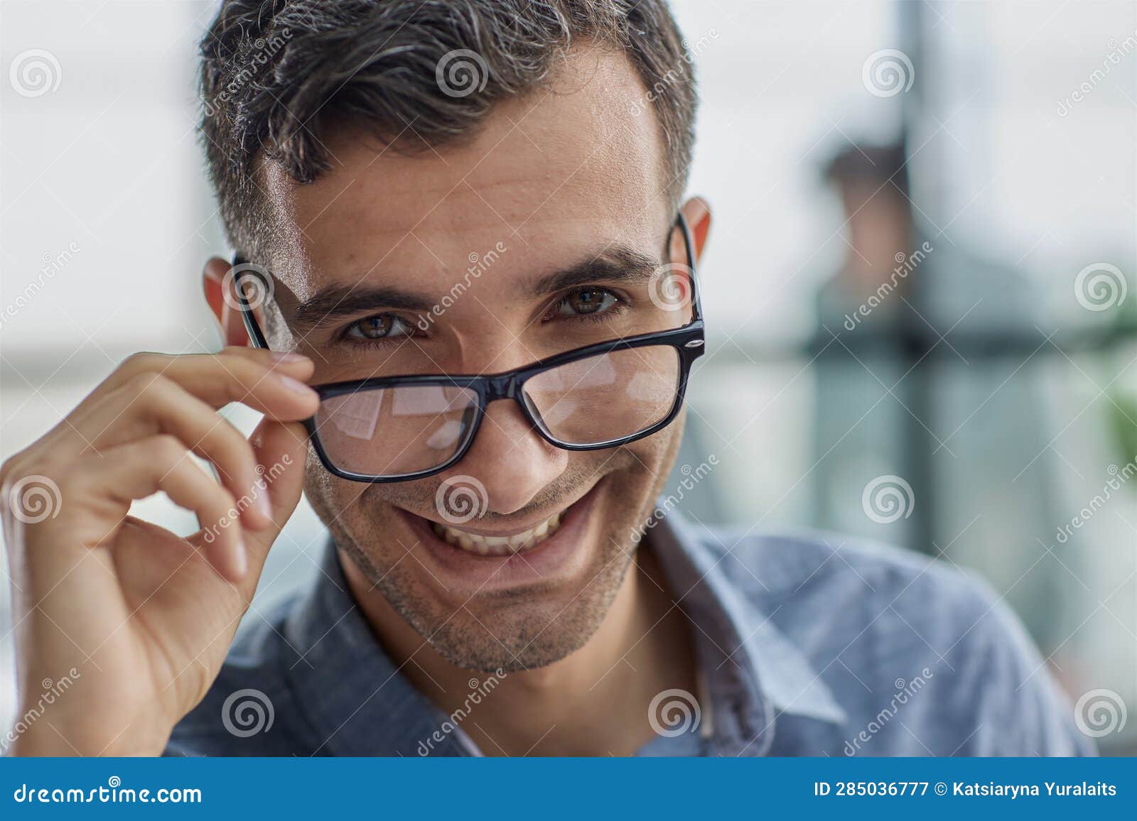Handsome Young Guy Adjusting His Glasses In His Office Stock Image
