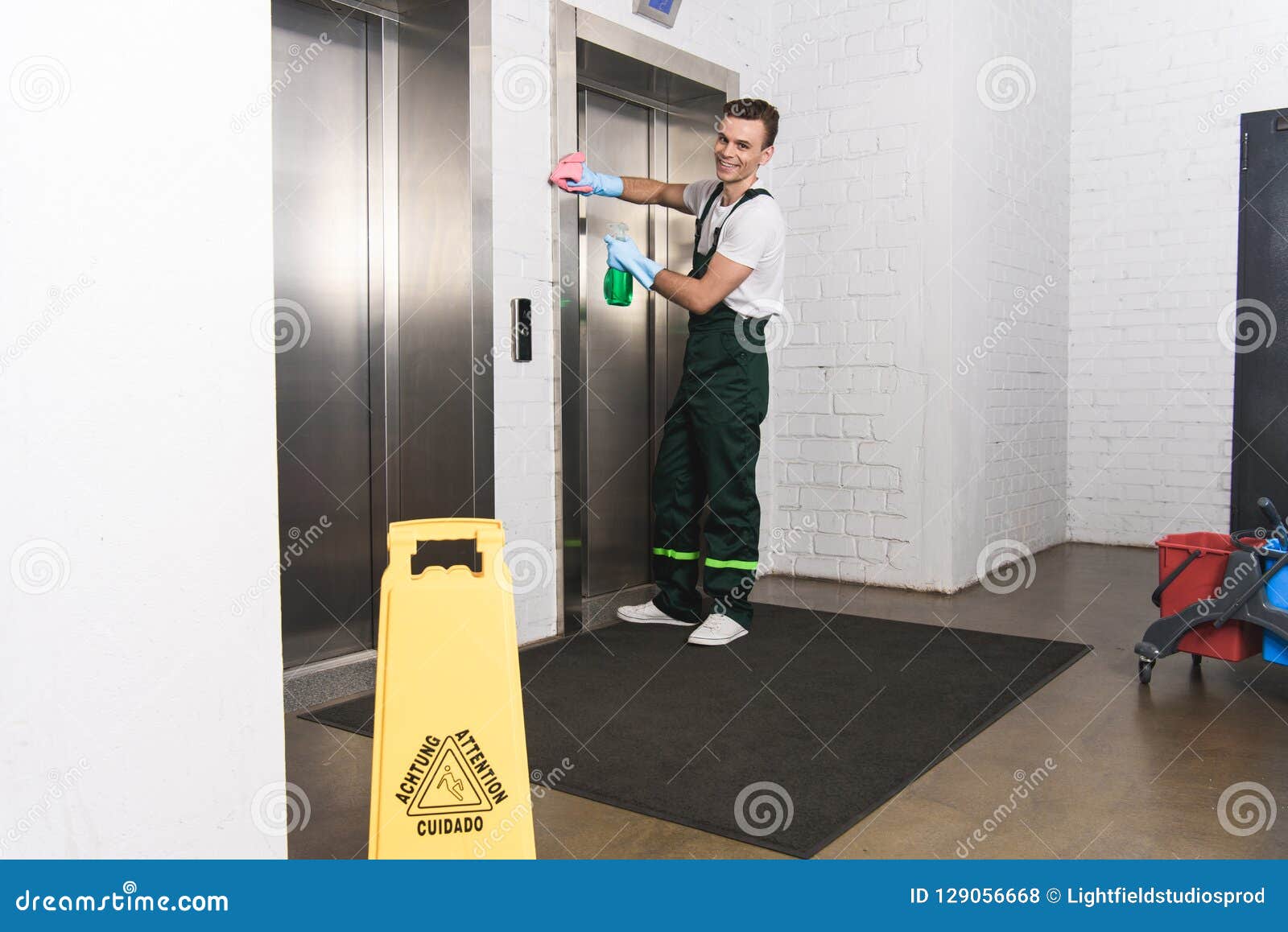 Handsome Young Janitor Cleaning Elevator and Smiling Stock Photo ...