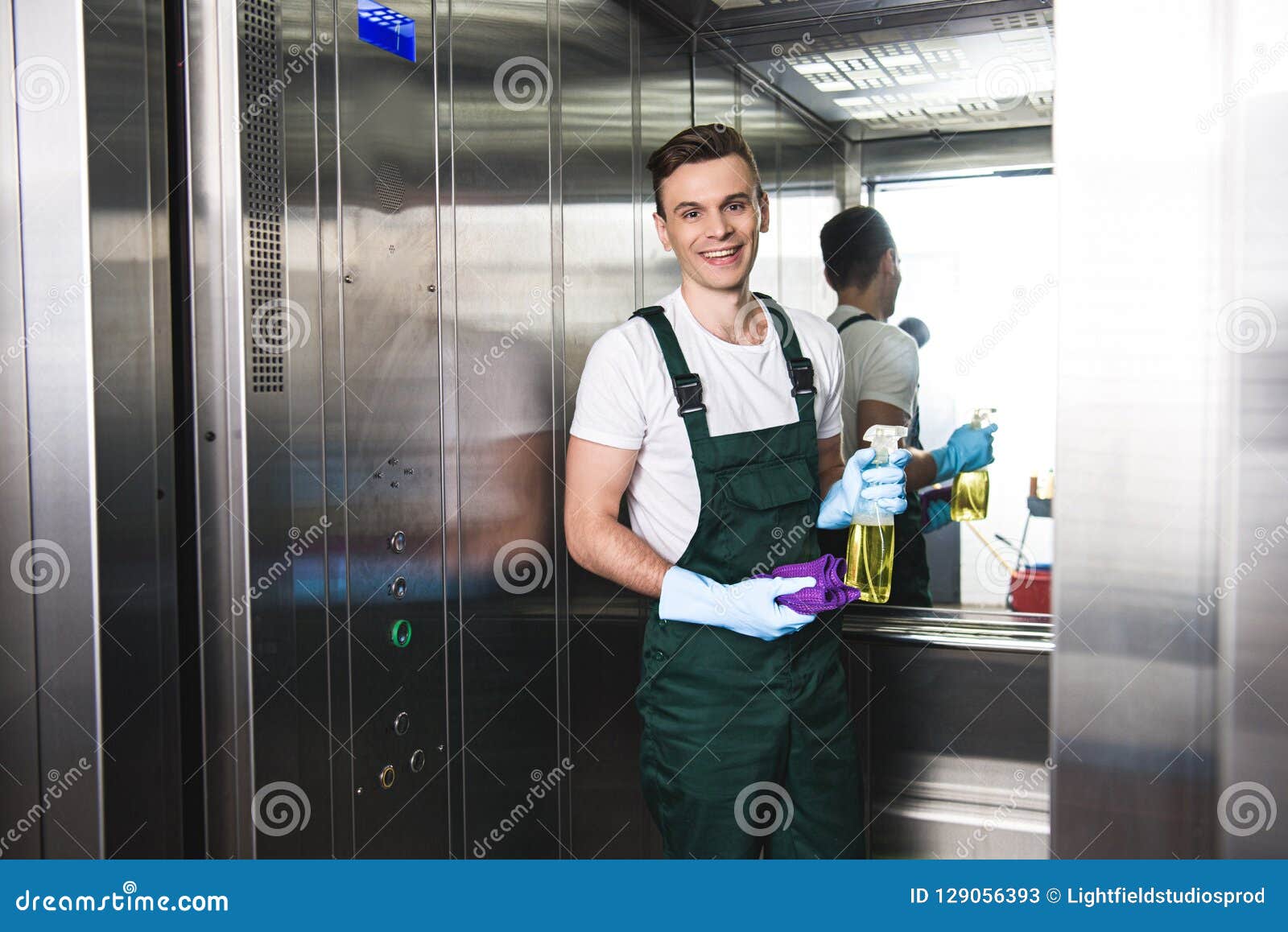 Handsome Young Janitor Holding Spray Bottle with Detergent and Rag ...