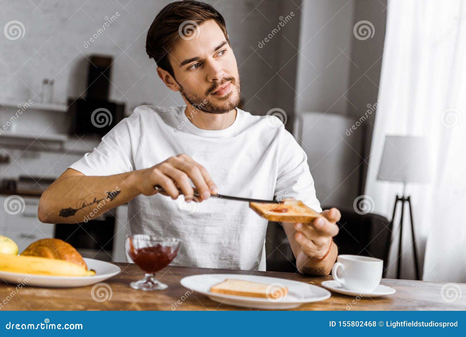 Handsome Young Man Applying Jam Onto Toast Stock Photo - Image of ...