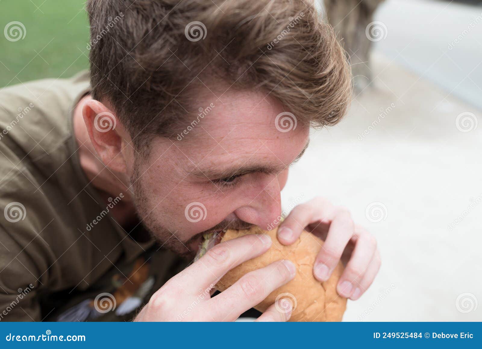 Young Man Eating Burger Outdoors Stock Photo - Image of bite, male ...