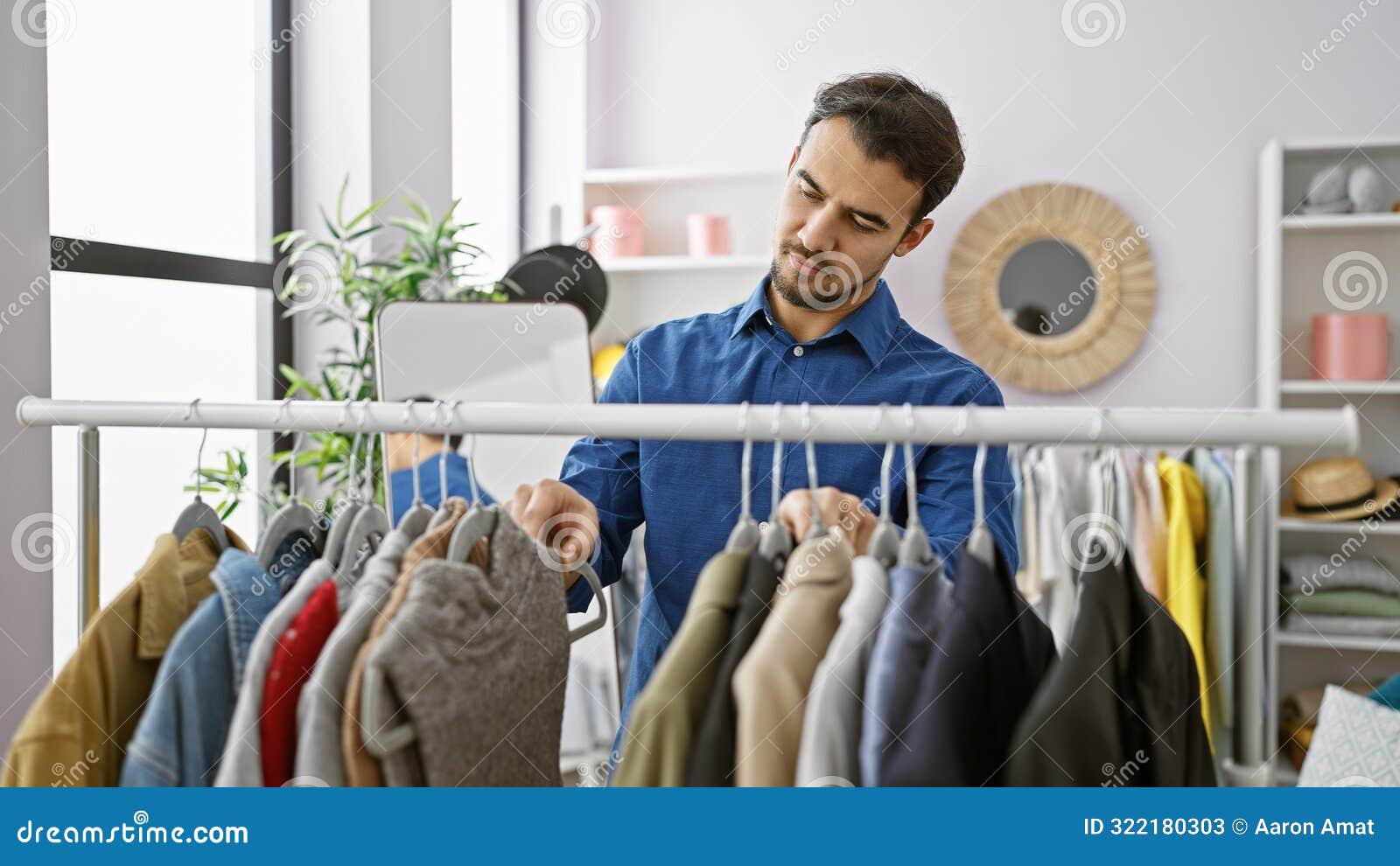 Handsome Young Man Browsing Clothing in a Modern Dressing Room Stock ...