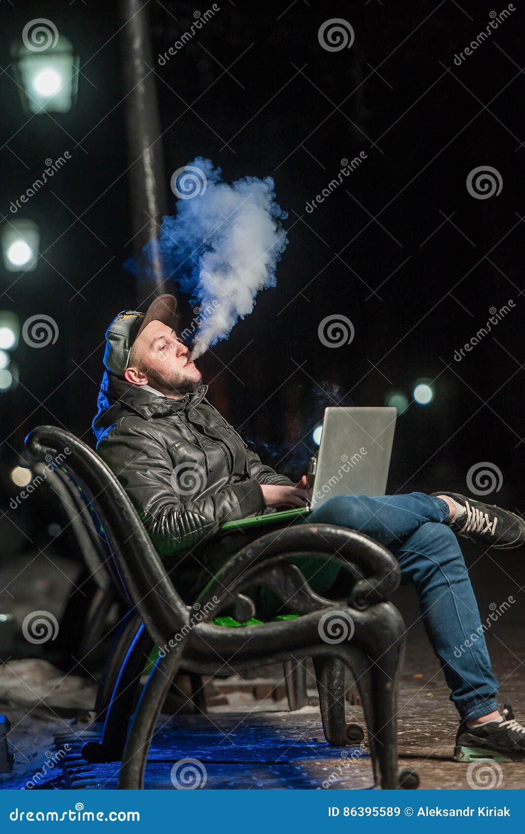 Handsome Young Man with a Computer and Smoking Electronic Cigarette ...