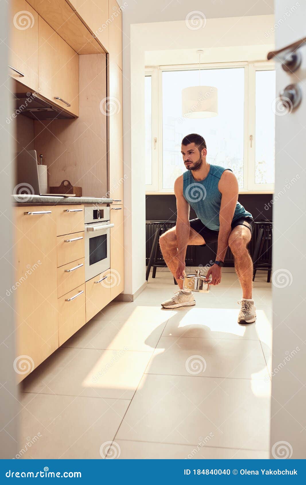 Handsome Young Man Doing Squats with Cooking Pot in Kitchen Stock Photo ...