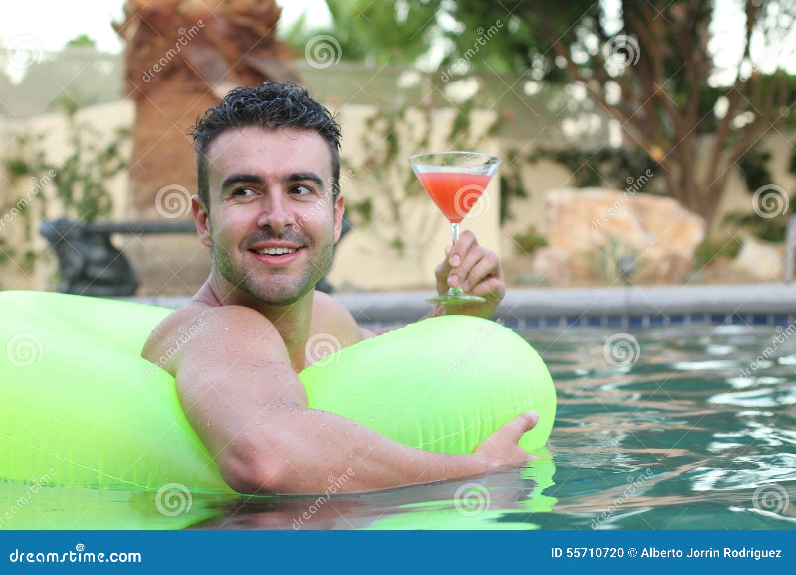 Handsome Young Man Drinking a Cocktail while Relaxing in a Swimming ...