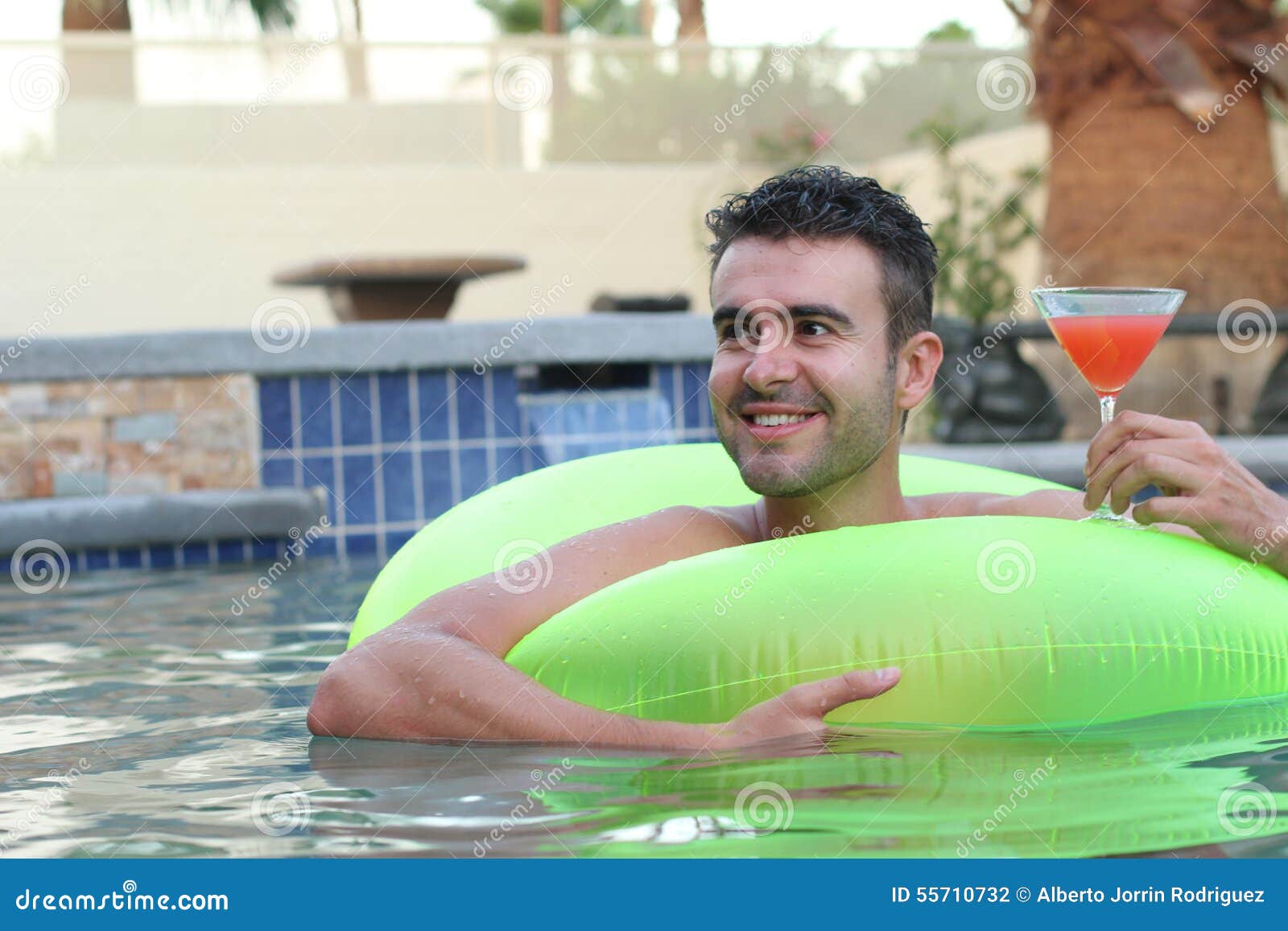 Handsome Young Man Drinking a Cocktail while Relaxing in a Swimming ...